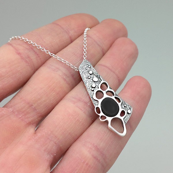Colgante artesanal en plata de ley y azabache natural.